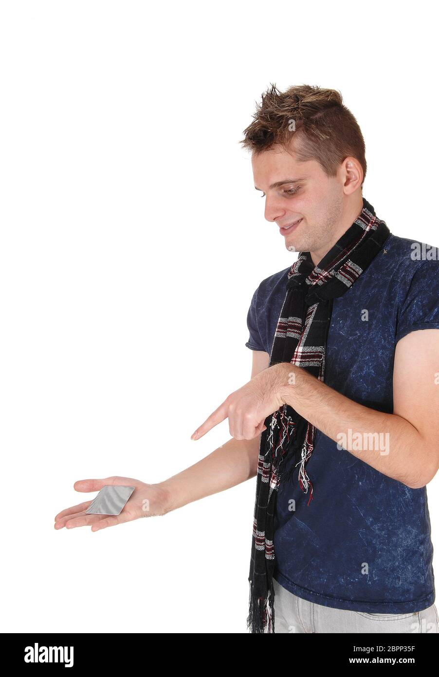 A close up image of a young man standing and holding a credit card in ...