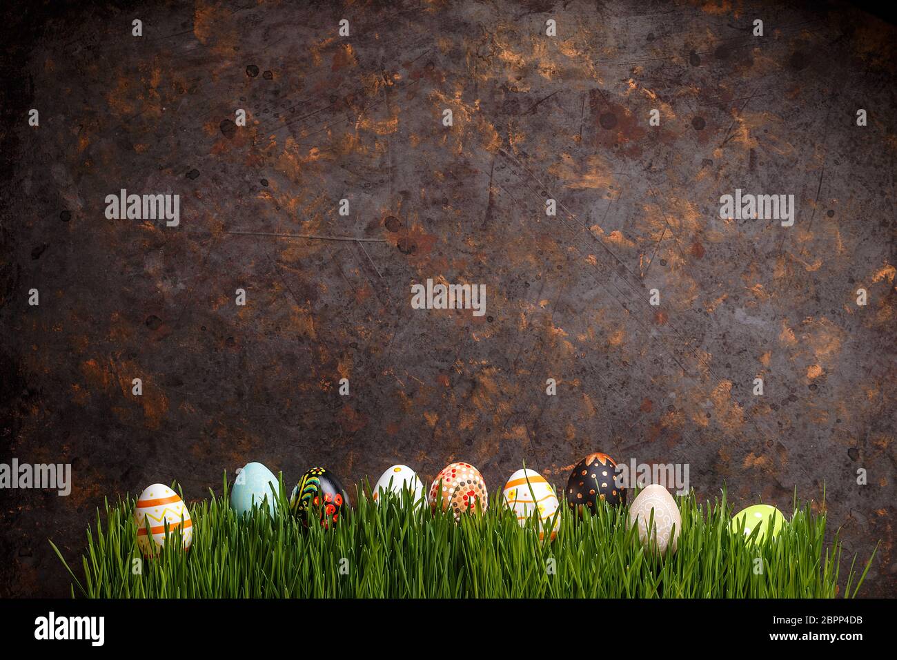 Easter eggs lined up in a row on grungy dark background, copy space ...