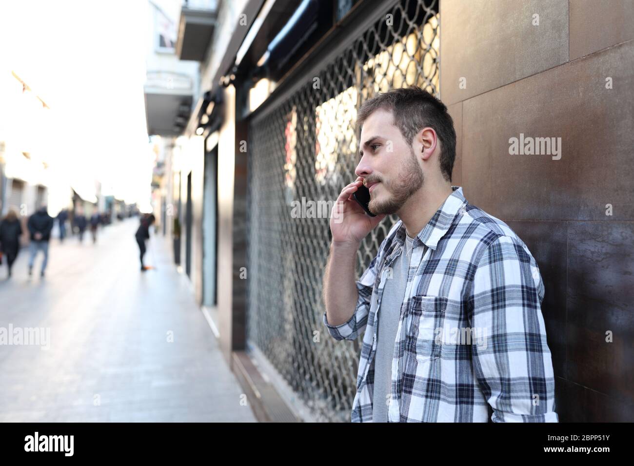 Side view portrait of a serious man talking on phone standing in the ...