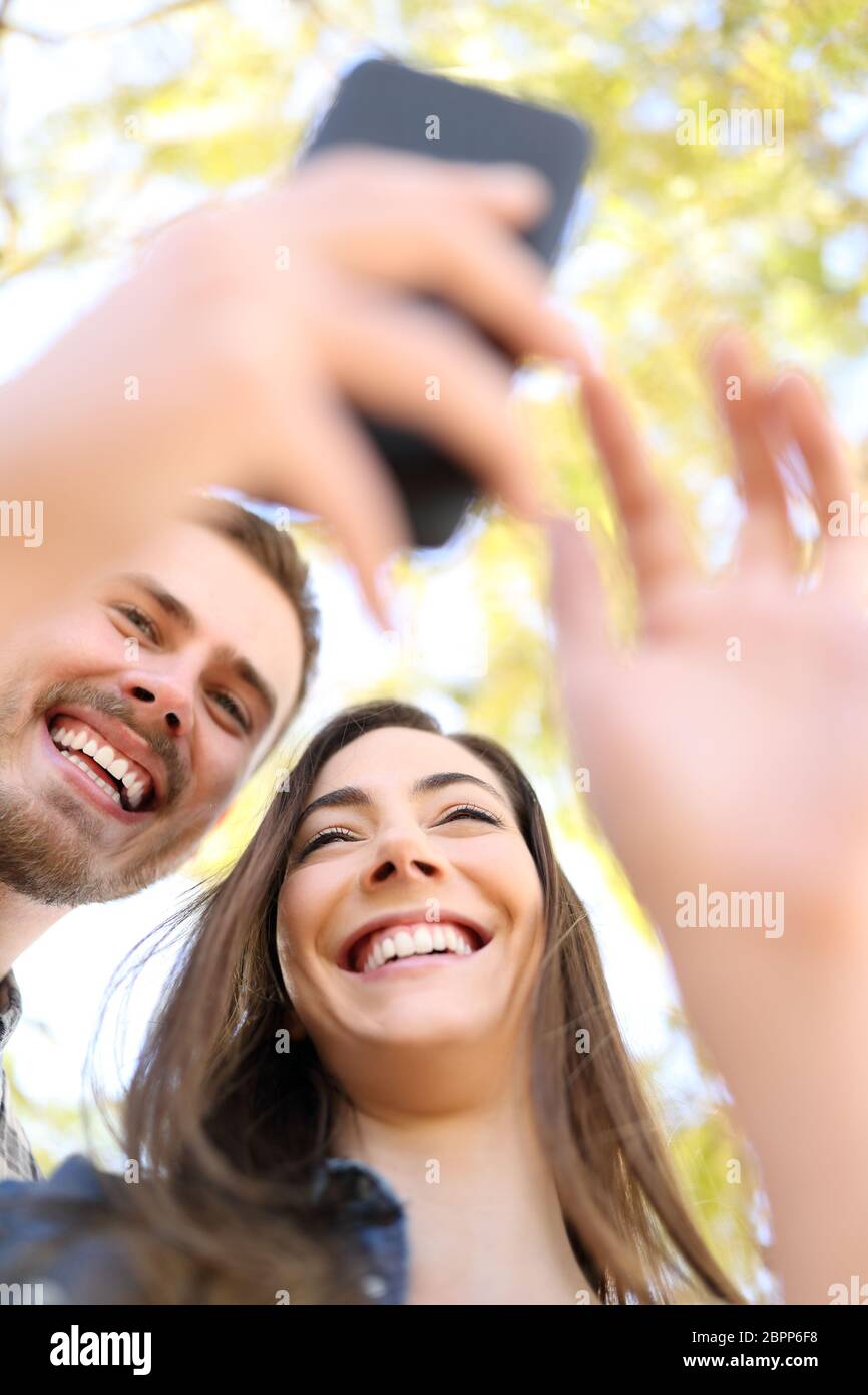Happy Couple Using Smart Phone Together Laughing Watching Online