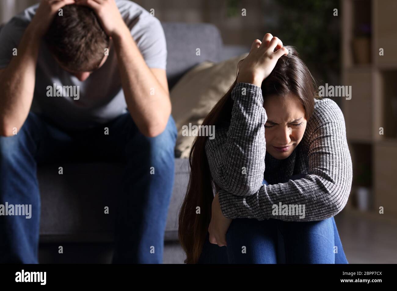 Sad couple after argument or breakup sitting on a sofa in the living ...