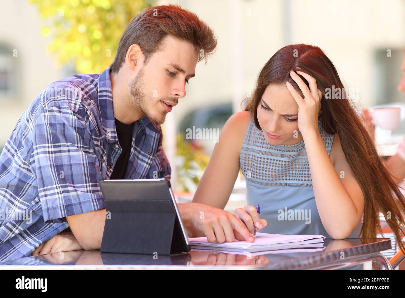 Student helping to learn a lesson to an attentive friend sitting in a ...