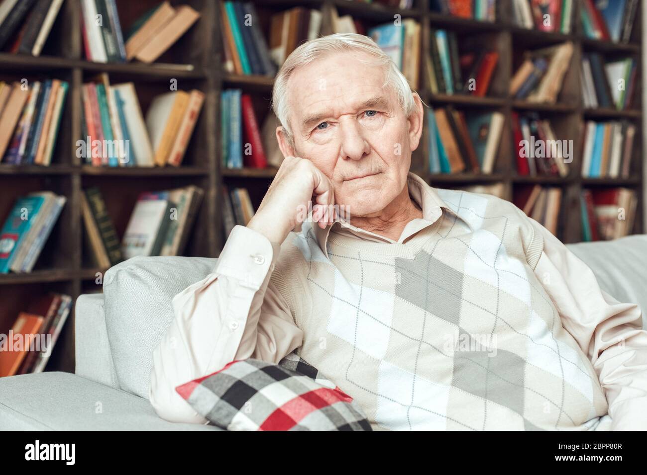 Senior man alone sitting at library thinking Stock Photo - Alamy