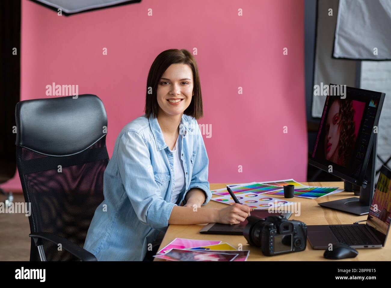 Portrait of graphic designer working in office with laptop,monitor ...