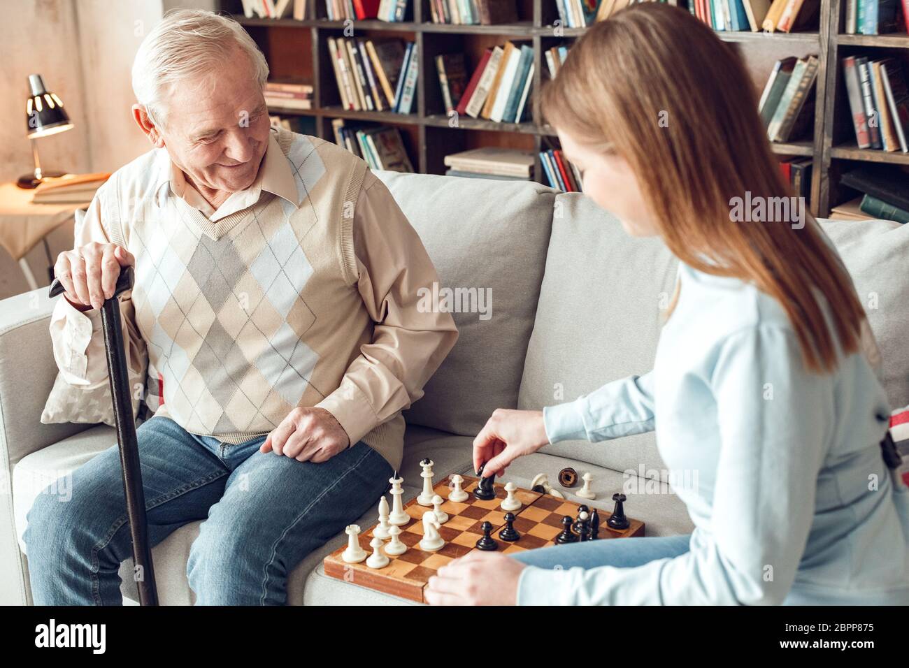Father and daughter at home library sitting playing chess happy Stock ...