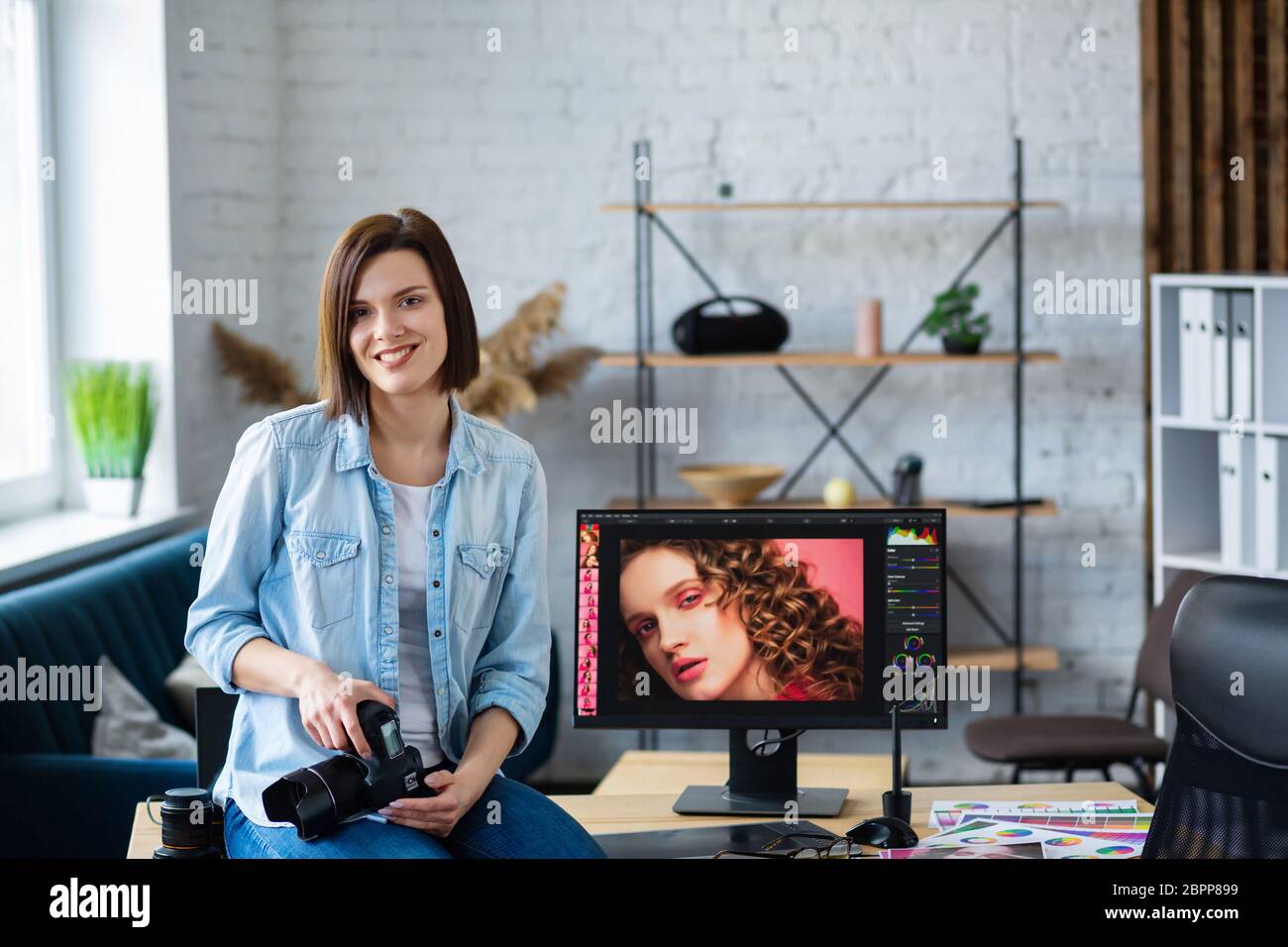 Portrait of professional photographer holding camera in photo studio ...