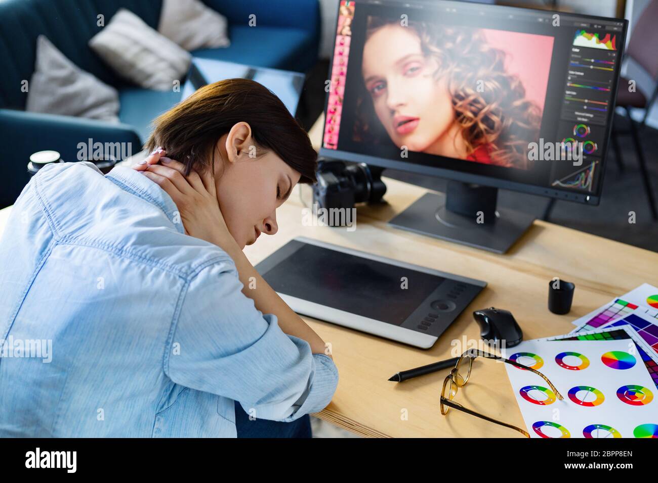 Portrait of tired graphic designer working overtime in office. Stressed ...