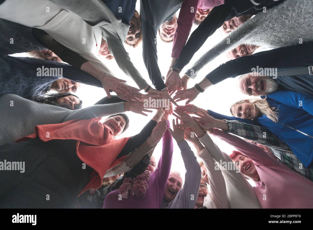 Creative business team stacking hands together in office Stock Photo ...