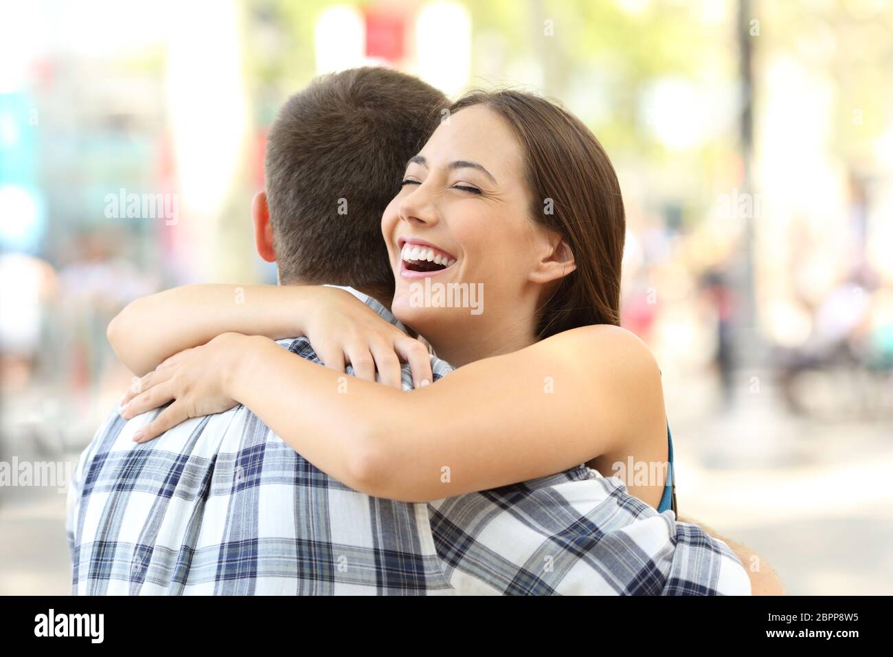 Happy couple or friends hugging after encounter on the street Stock ...