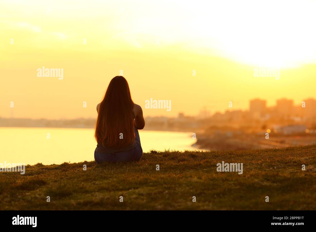 Back View Backlight Portrait Of A Single Woman Watching A Sunset On The