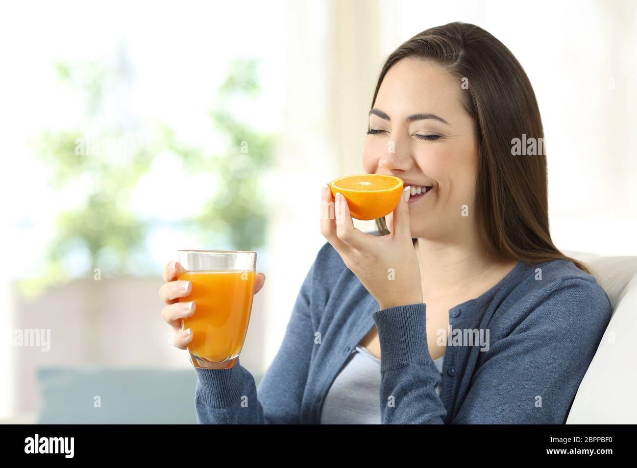 Woman smelling orange fruit hi-res stock photography and images - Alamy