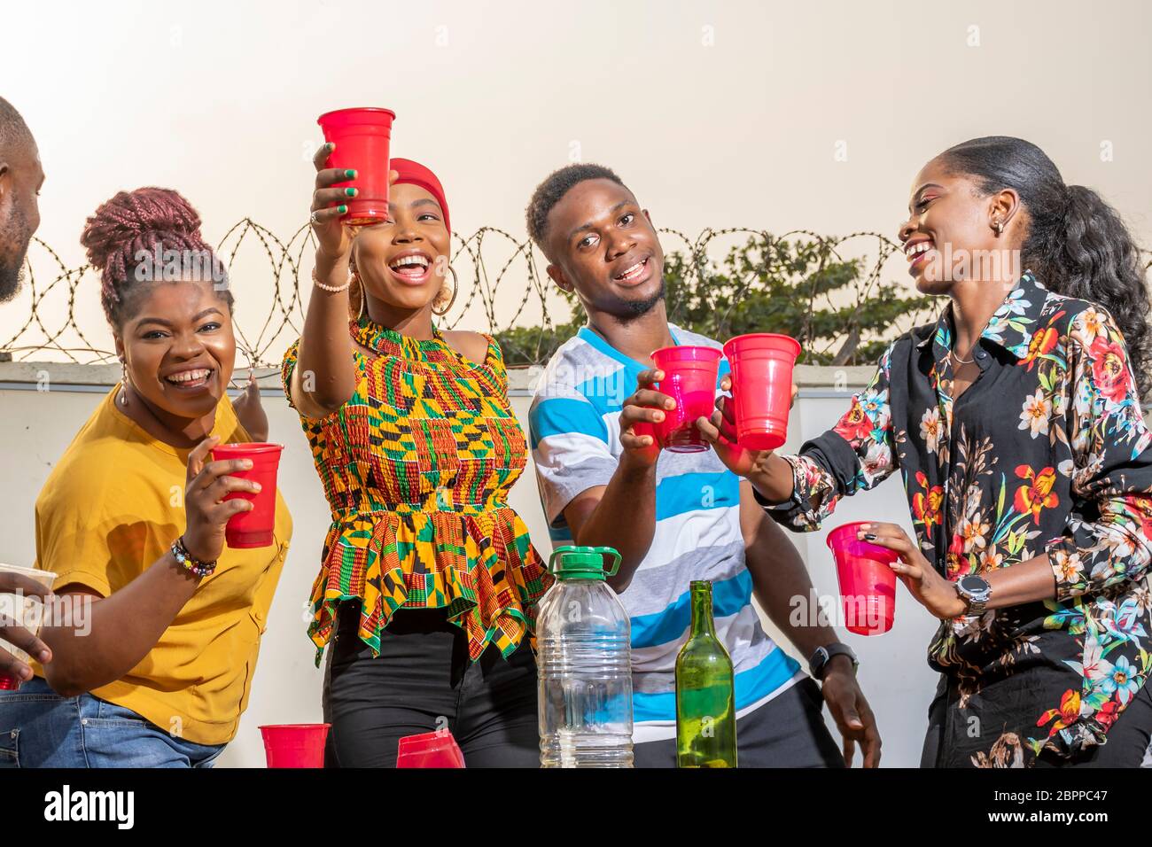 group of young african friends having a get together, make a toast ...