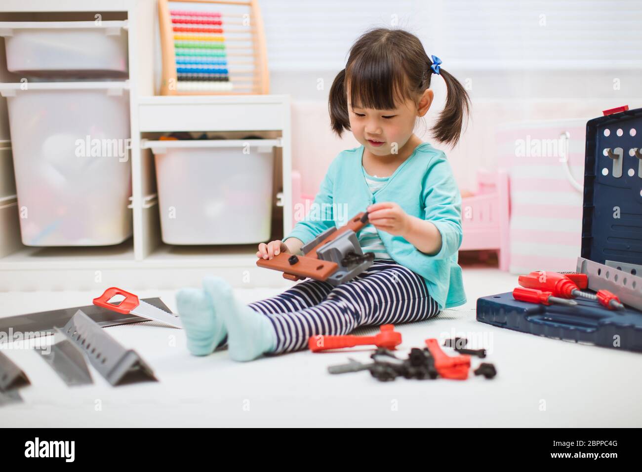 toddler girl pretend using DIY tool at home against white backgrround ...