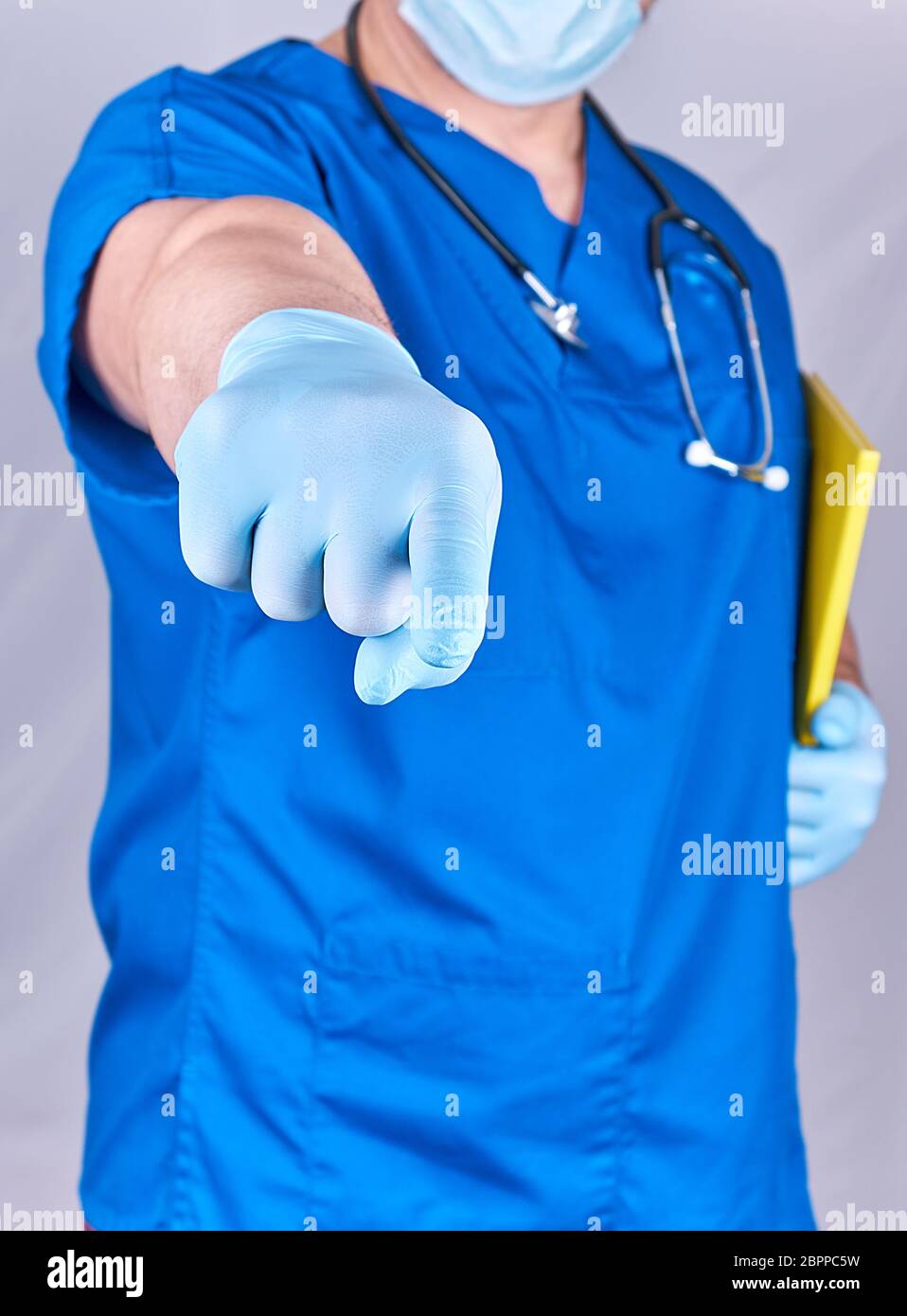doctor in blue uniform and latex gloves showing hand gesture, gray ...