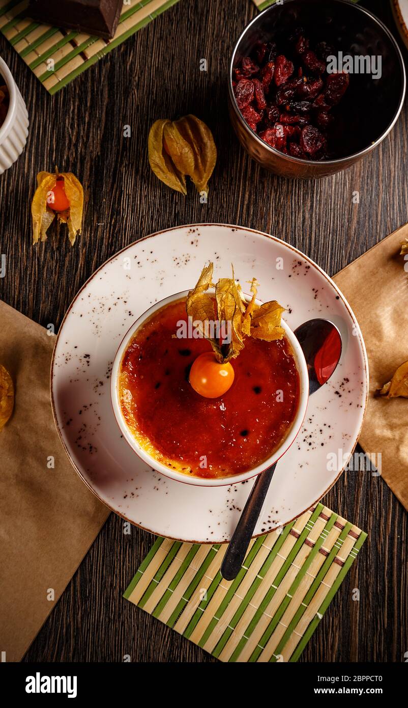 Flat lay of Creme brulee in a white bowl with sugar crust decorated ...