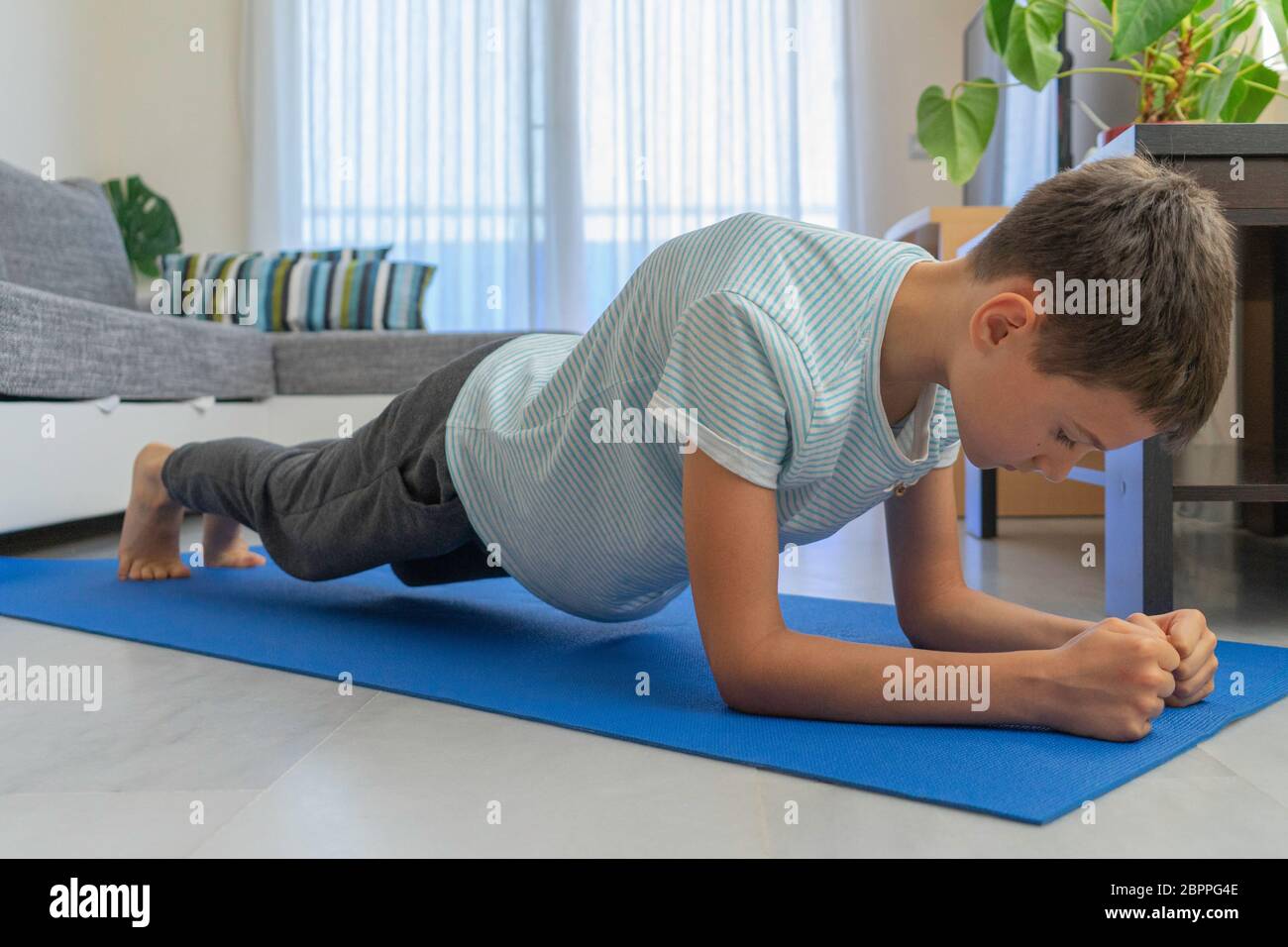 Kid doing sport exercises on mat at home. Sport, healhty lifestyle ...