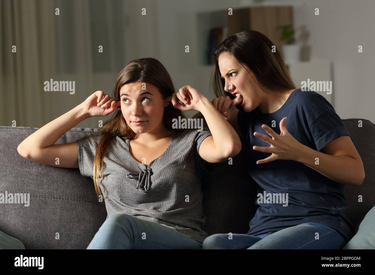Angry woman scolding to another ignoring her sitting on a couch in the ...