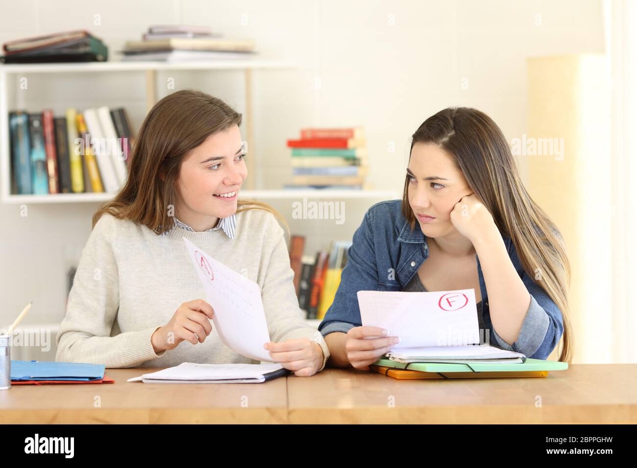 Two students with failed and approved tests talking about her exam ...
