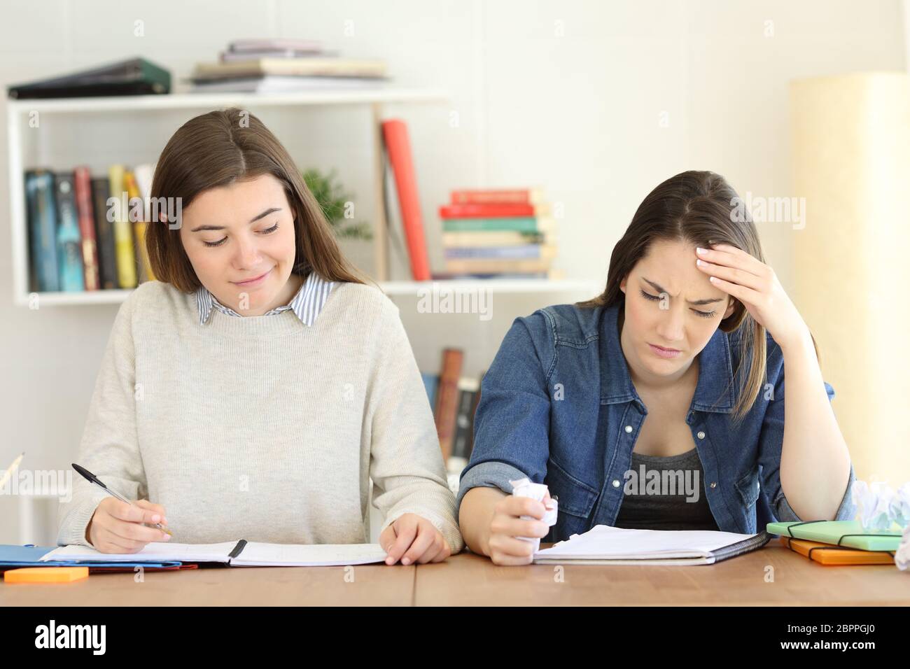 Resentful student happy to see her frustrated friend failing Stock ...