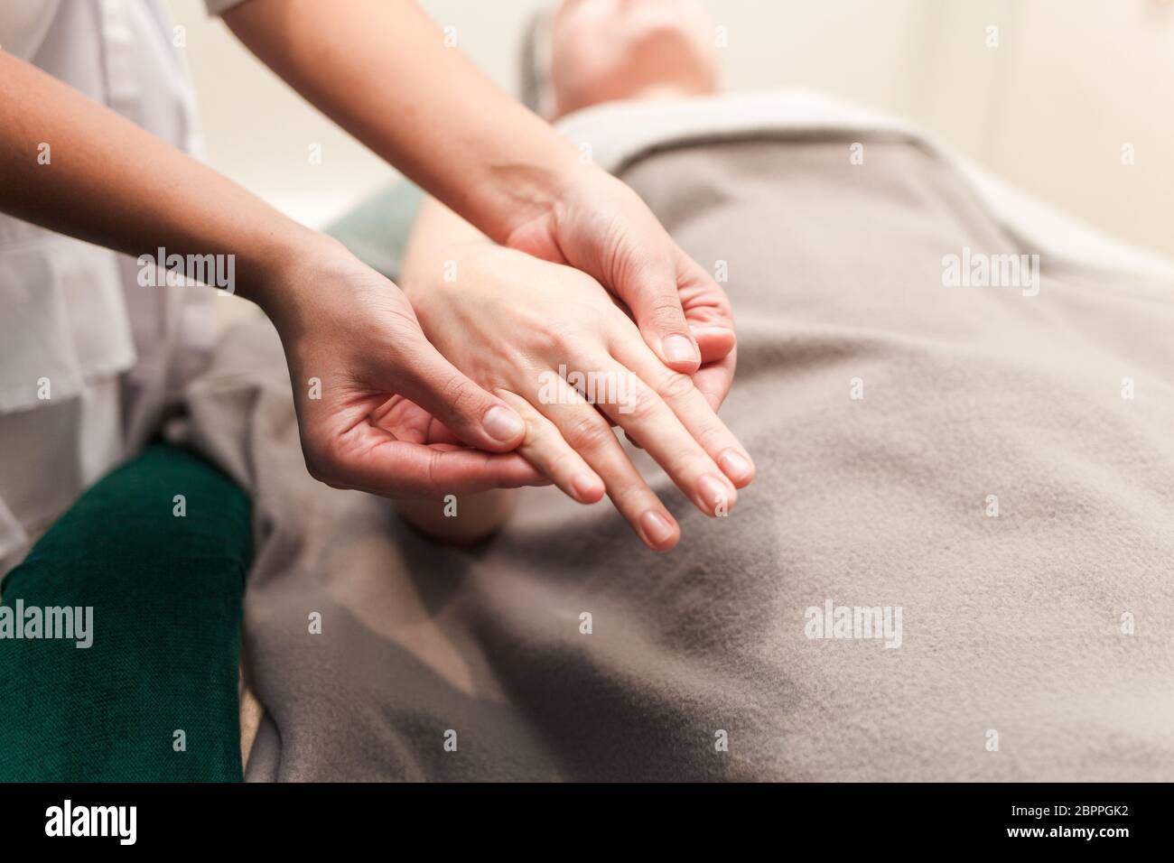 Doctor cosmetologist massages the hands of his patient. Client of a ...