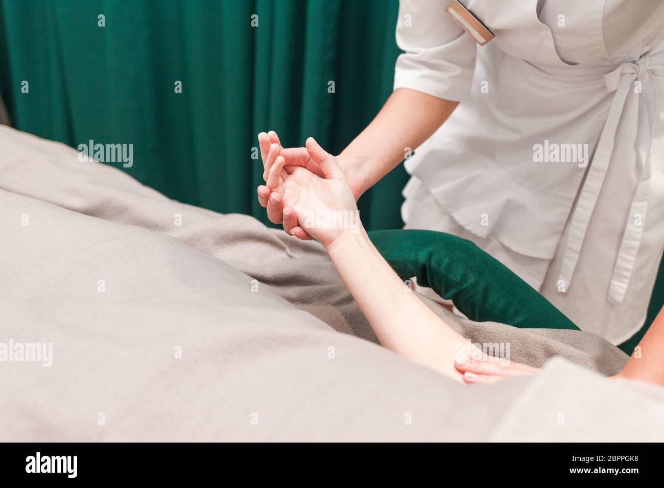 Doctor cosmetologist massages the hands of his patient. Client of a ...