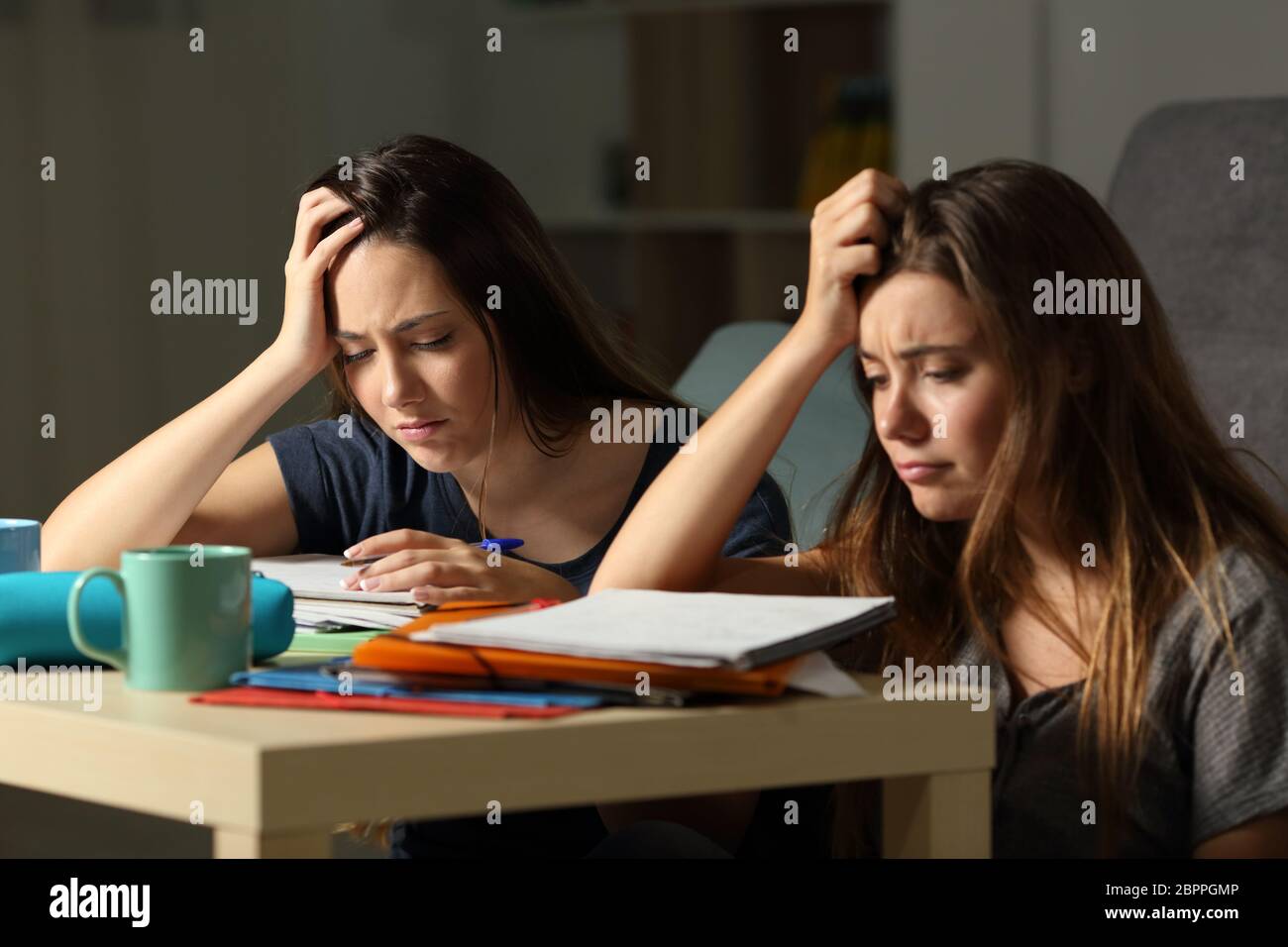Frustrated students studying hard late hours in the night at home Stock ...
