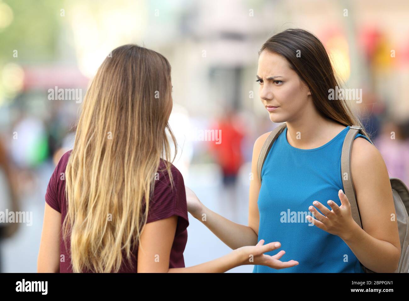 Two angry friends having a serious conversation outdoors on the street ...