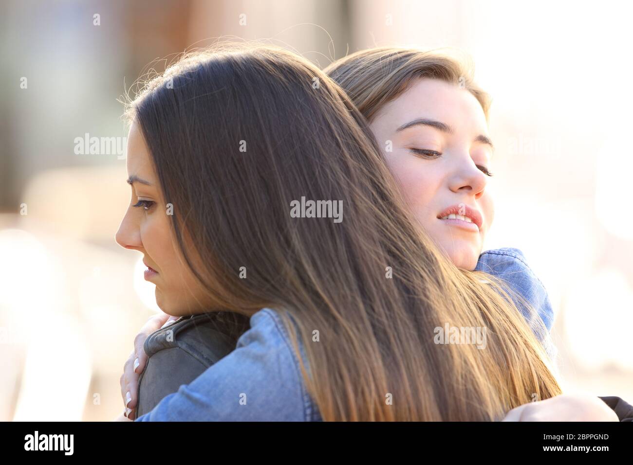 Two hypocritical angry friends embracing in the street Stock Photo - Alamy