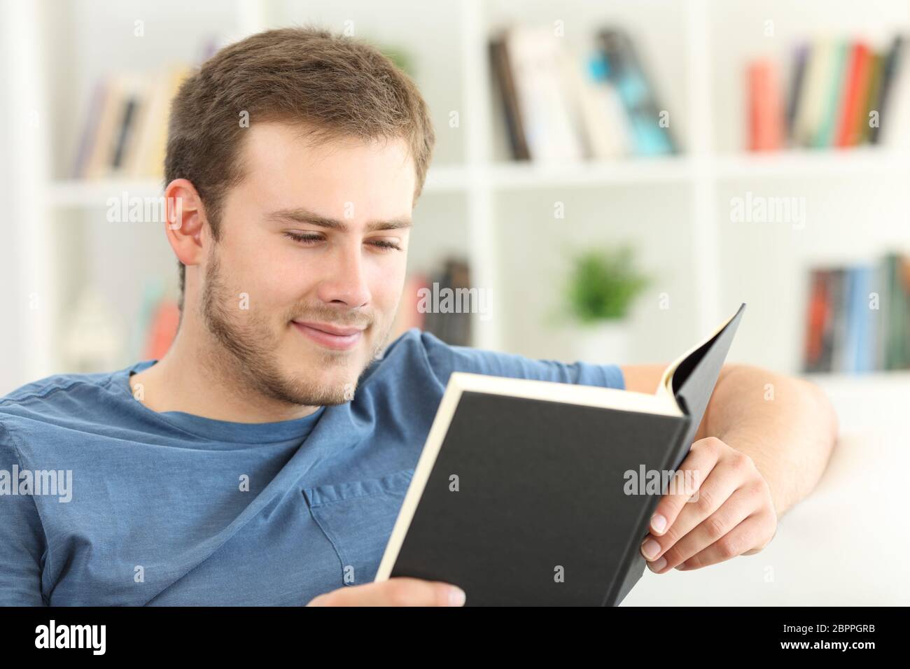 Teen boy reading book on sofa hi-res stock photography and images - Alamy