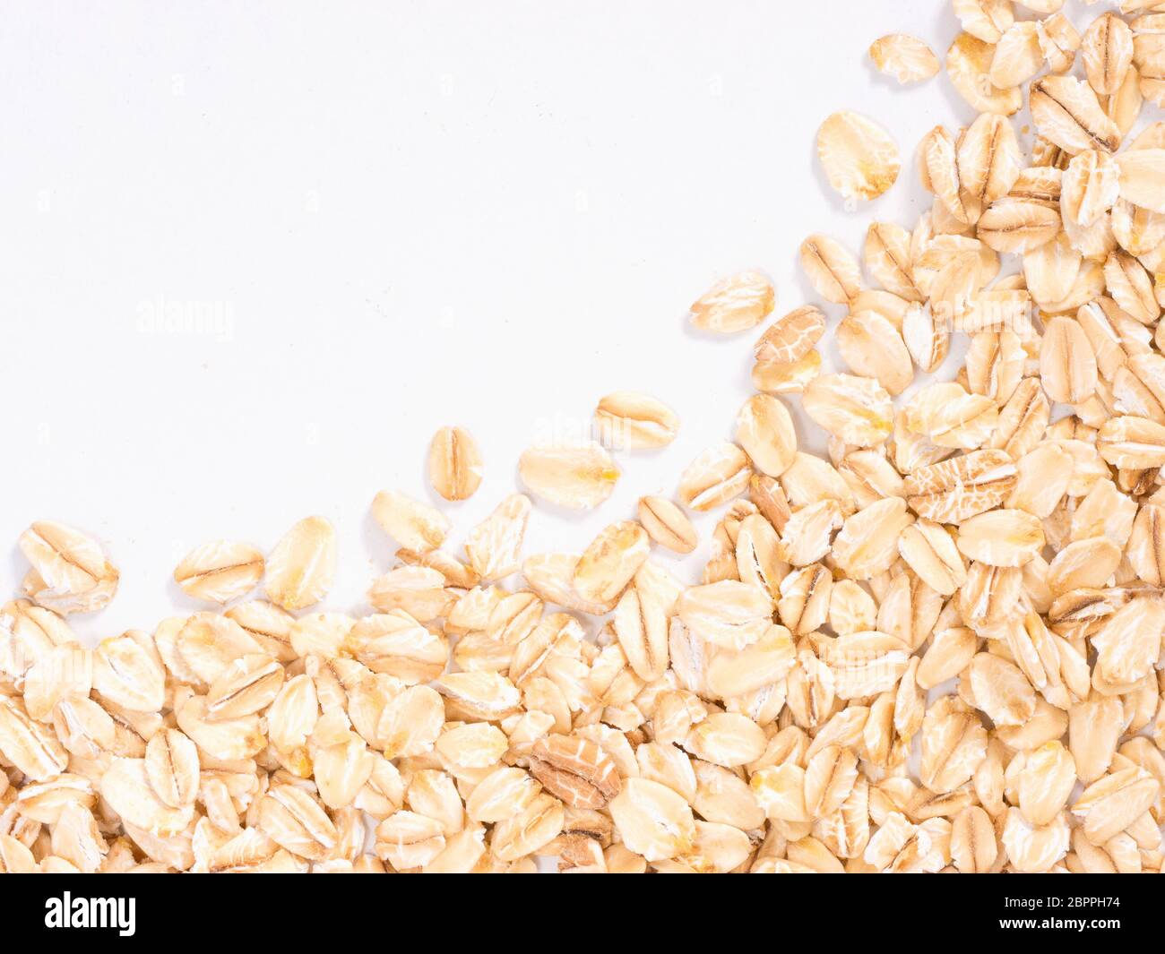 raw oatmeal on white background with copy space. Isolated one edge. Top ...