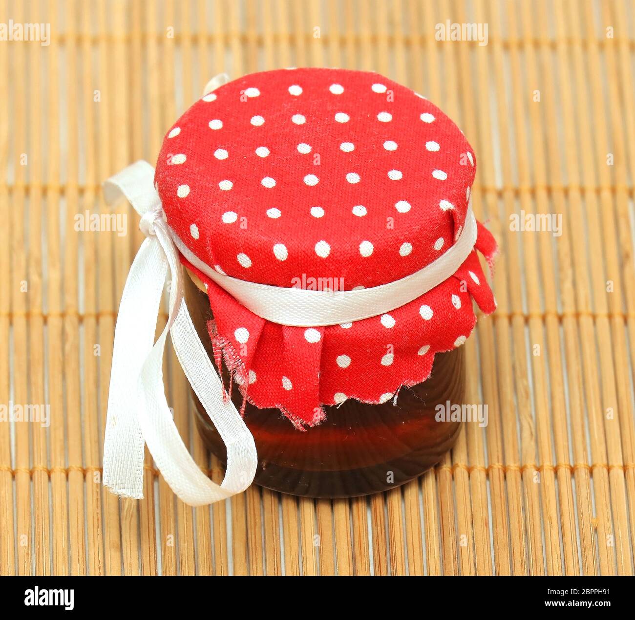 Small jam jar with retro polka dot cover on rattan background Stock ...
