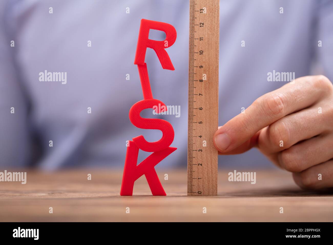 Close-up Of Person's Hand Holding Wooden Ruler And Red Risk Word Stock ...