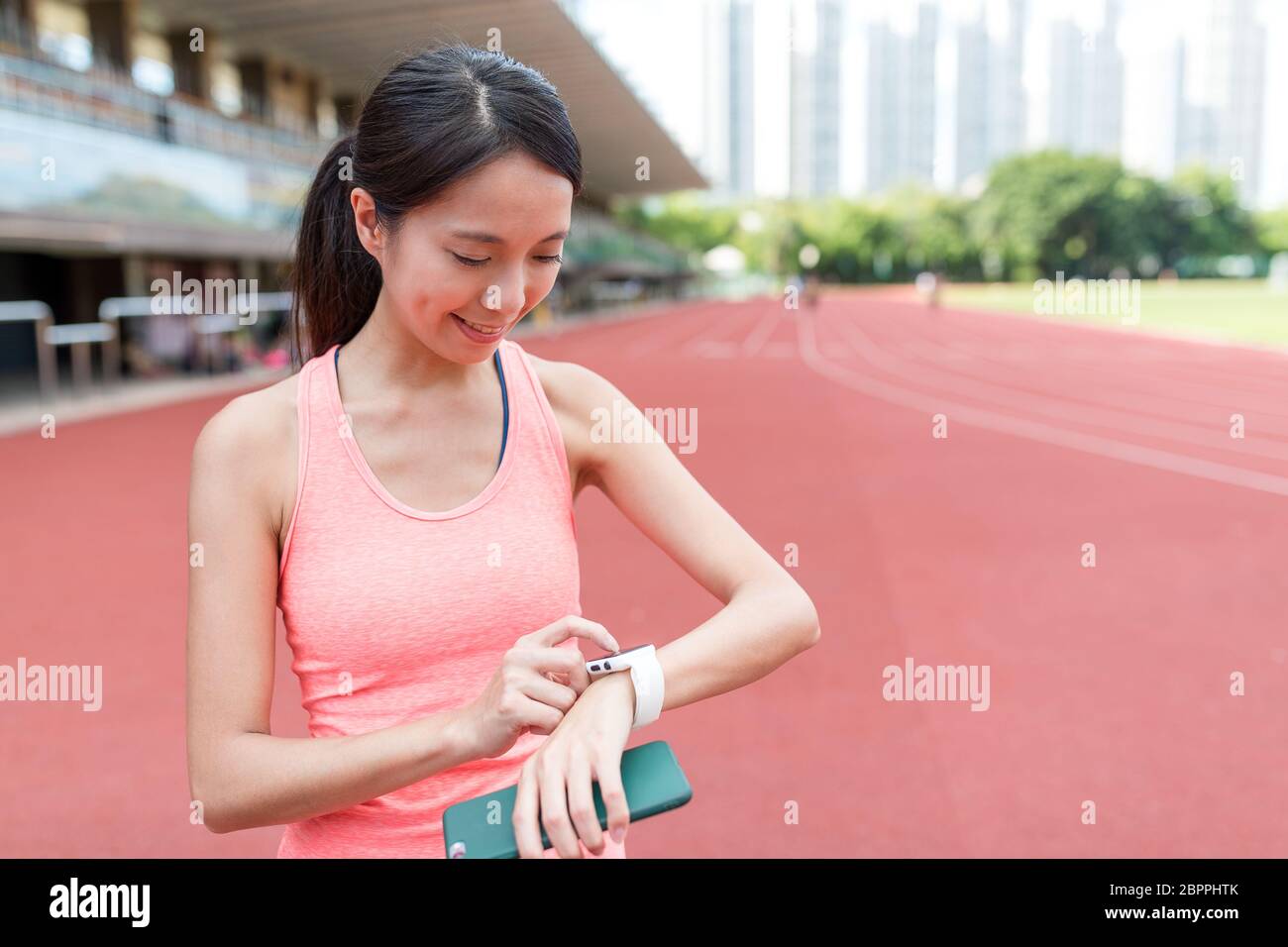 Sport woman using wearable smart watch in sport stadium Stock Photo - Alamy
