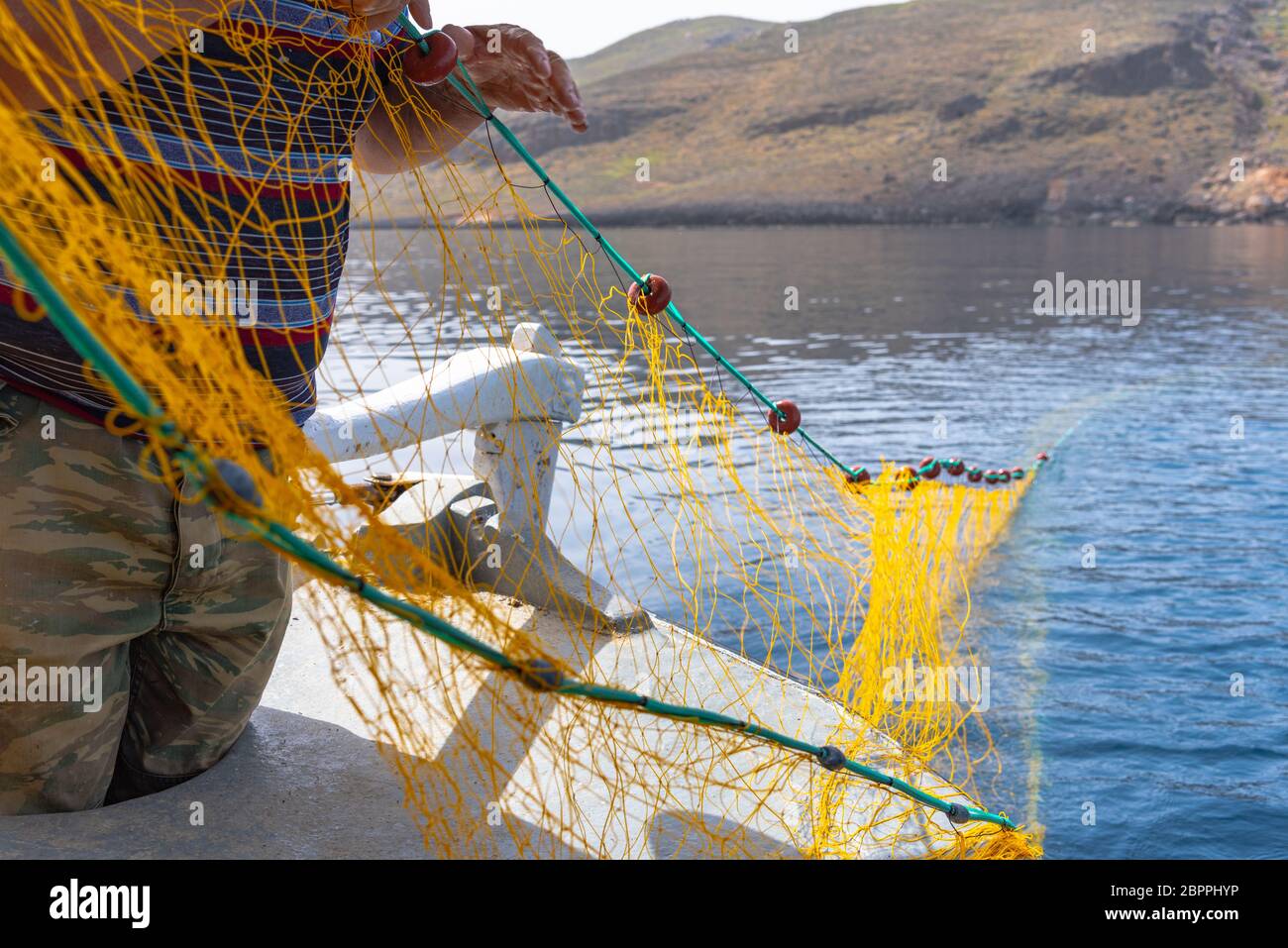 Fisherman is fishing fresh fishes using yellow fishing nets, on fishing ...