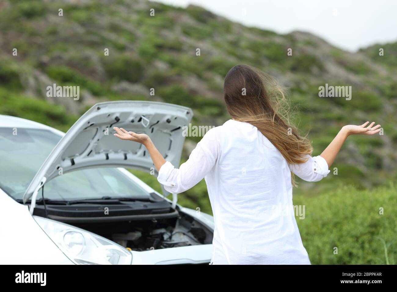 Frustrated driver looking at broken down engine of a car Stock Photo ...
