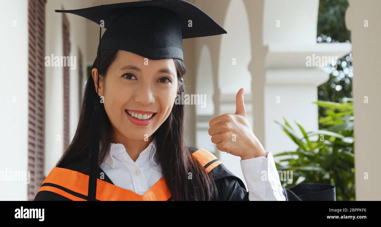Woman get graduation and show thumb up Stock Photo - Alamy