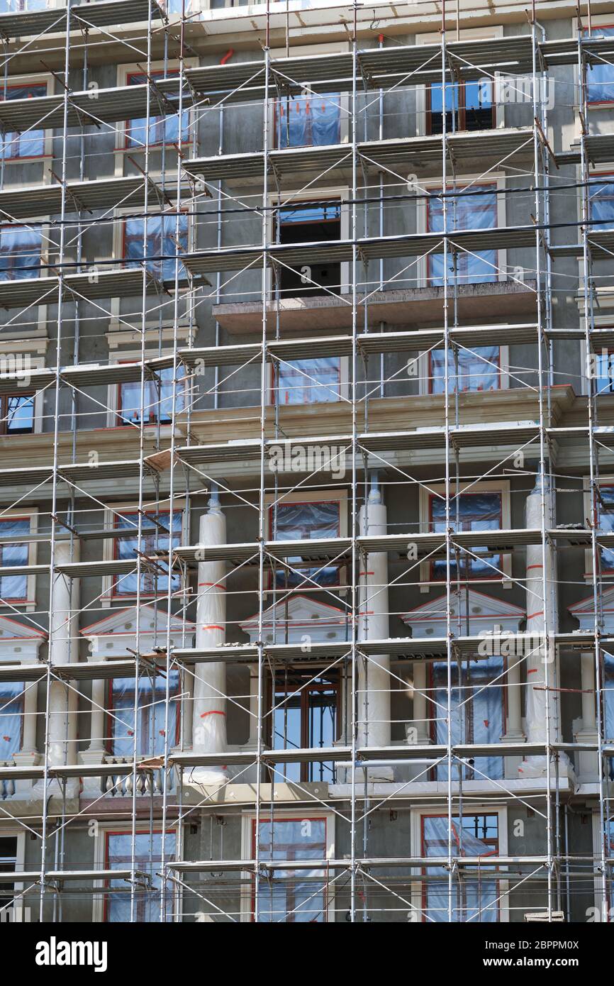 scaffolding at the facade of a building under construction, multi ...