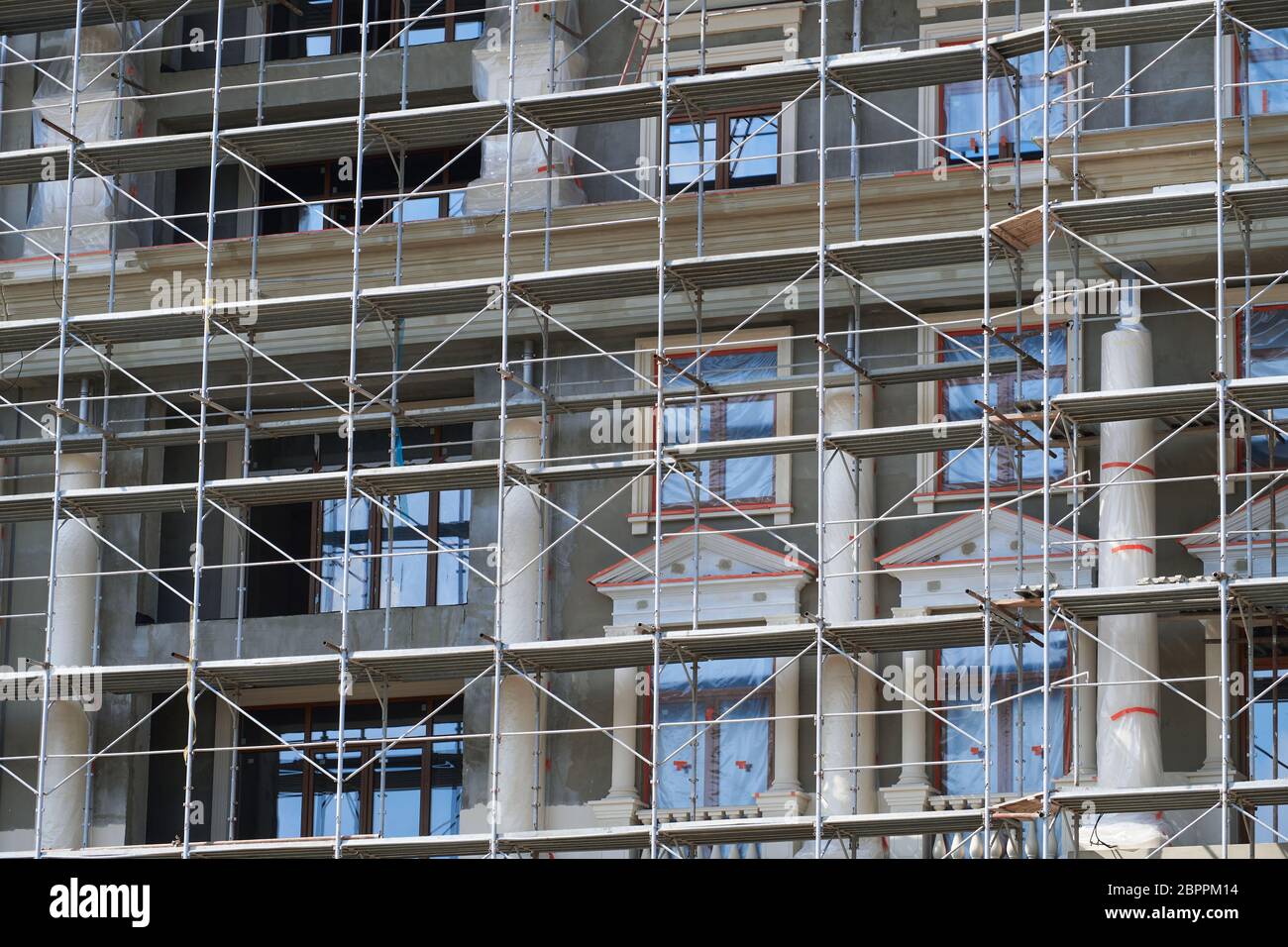 scaffolding at the facade of a building under construction, multi ...