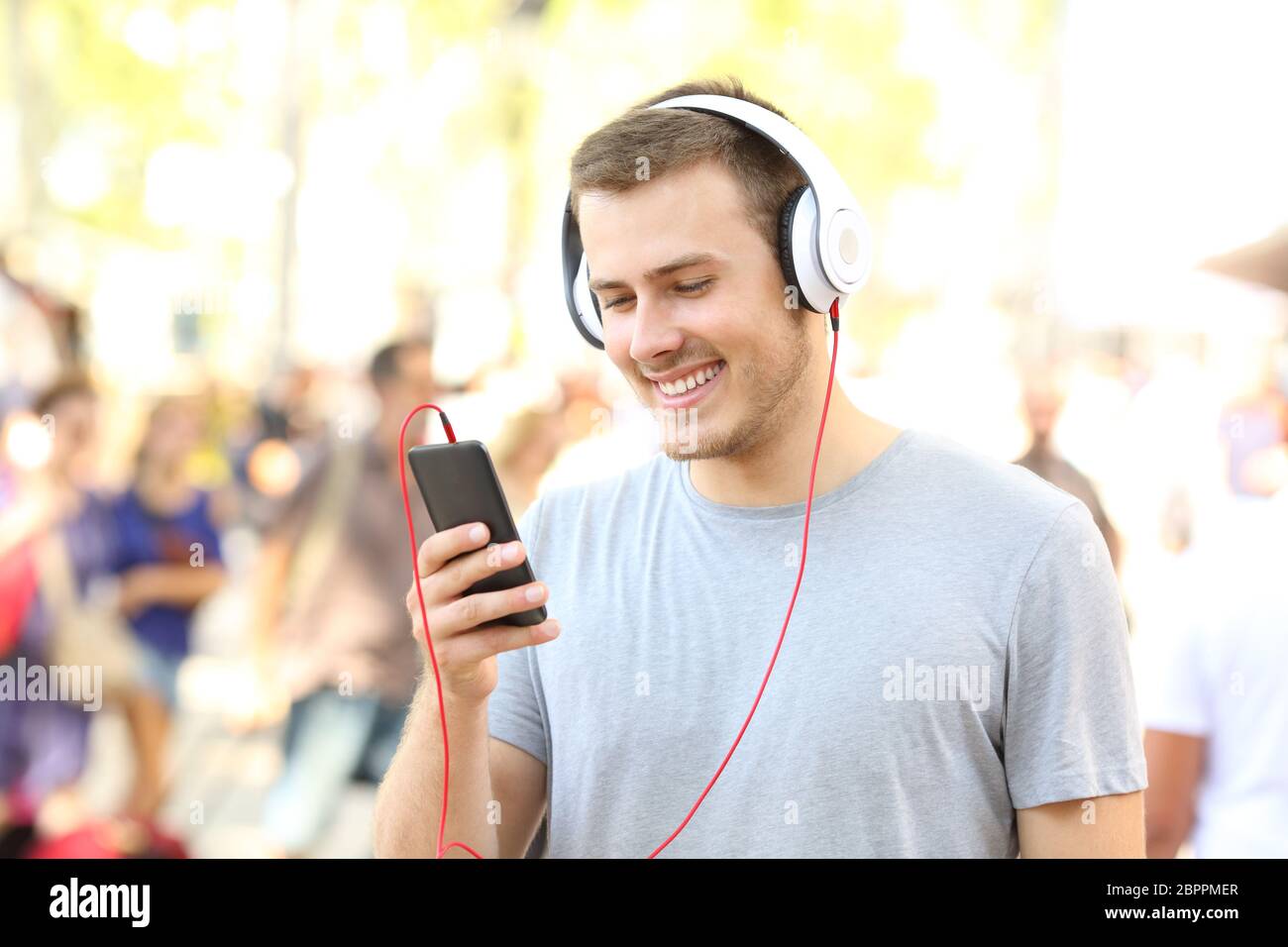 Boy using phone with headset on street hi-res stock photography and ...