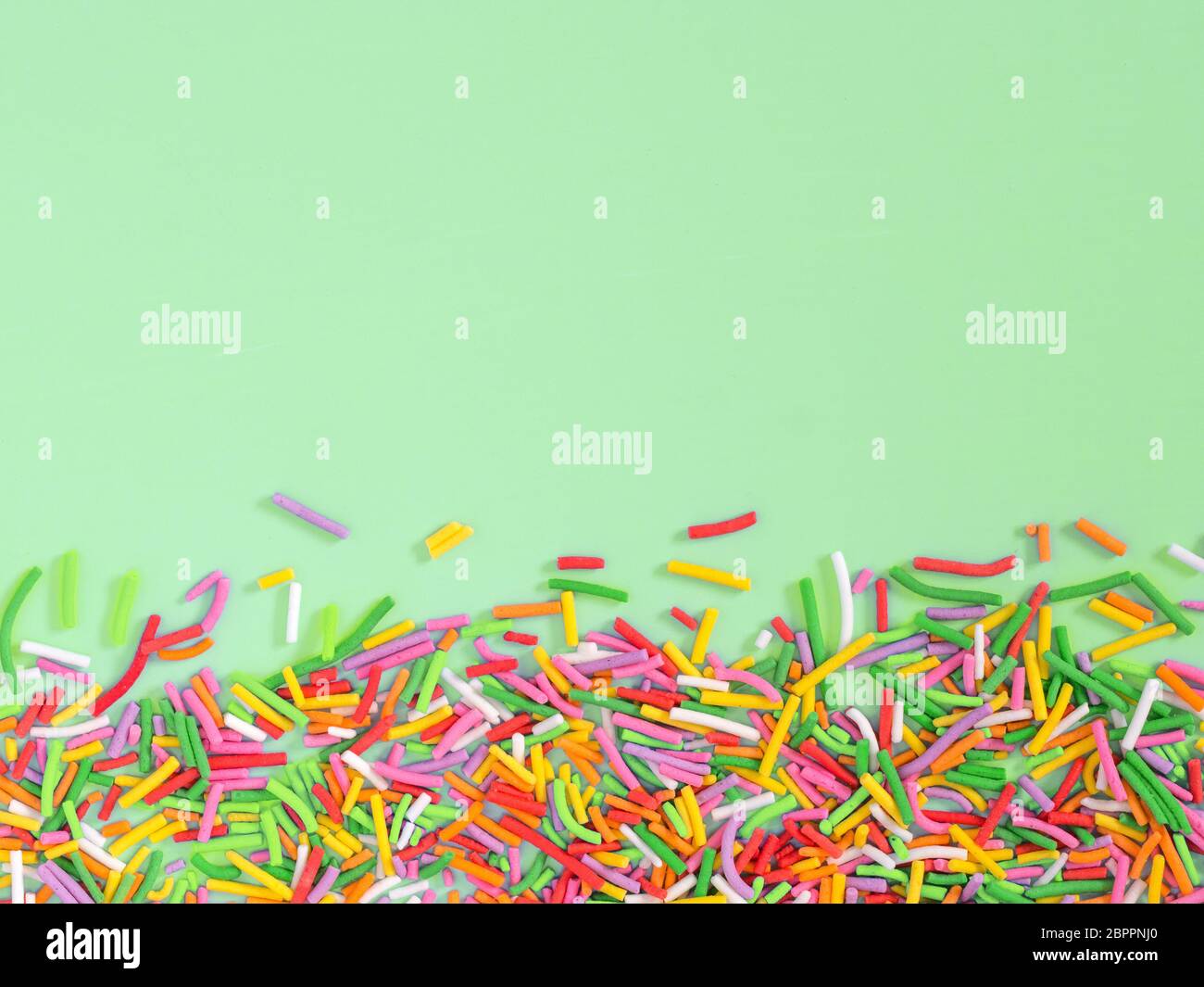 Border frame of colorful sprinkles on green background with copyspace ...