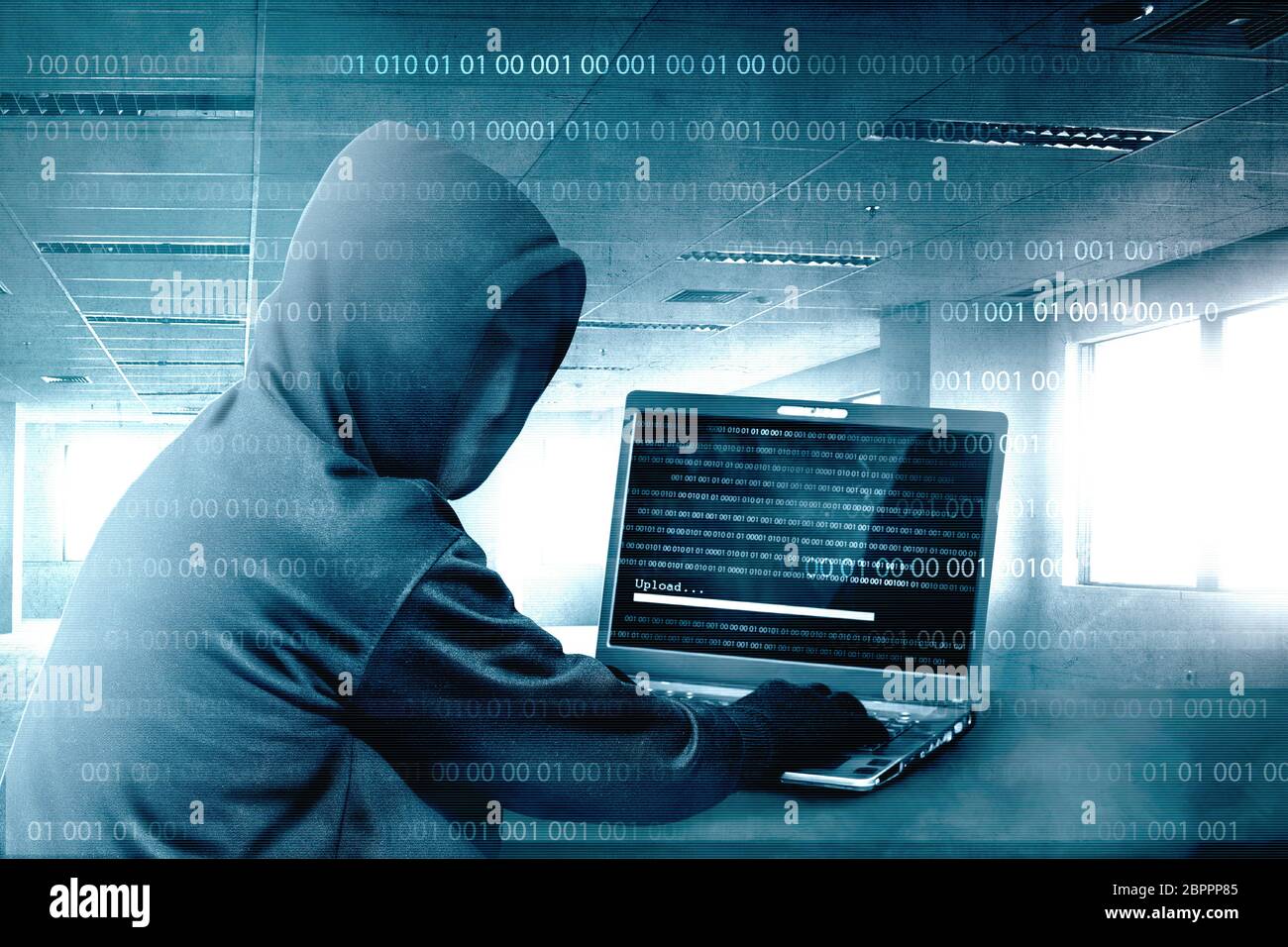 Hacker In Black Hoodie Using Laptop On The Desk To Hacking System With Binary Code And Upload