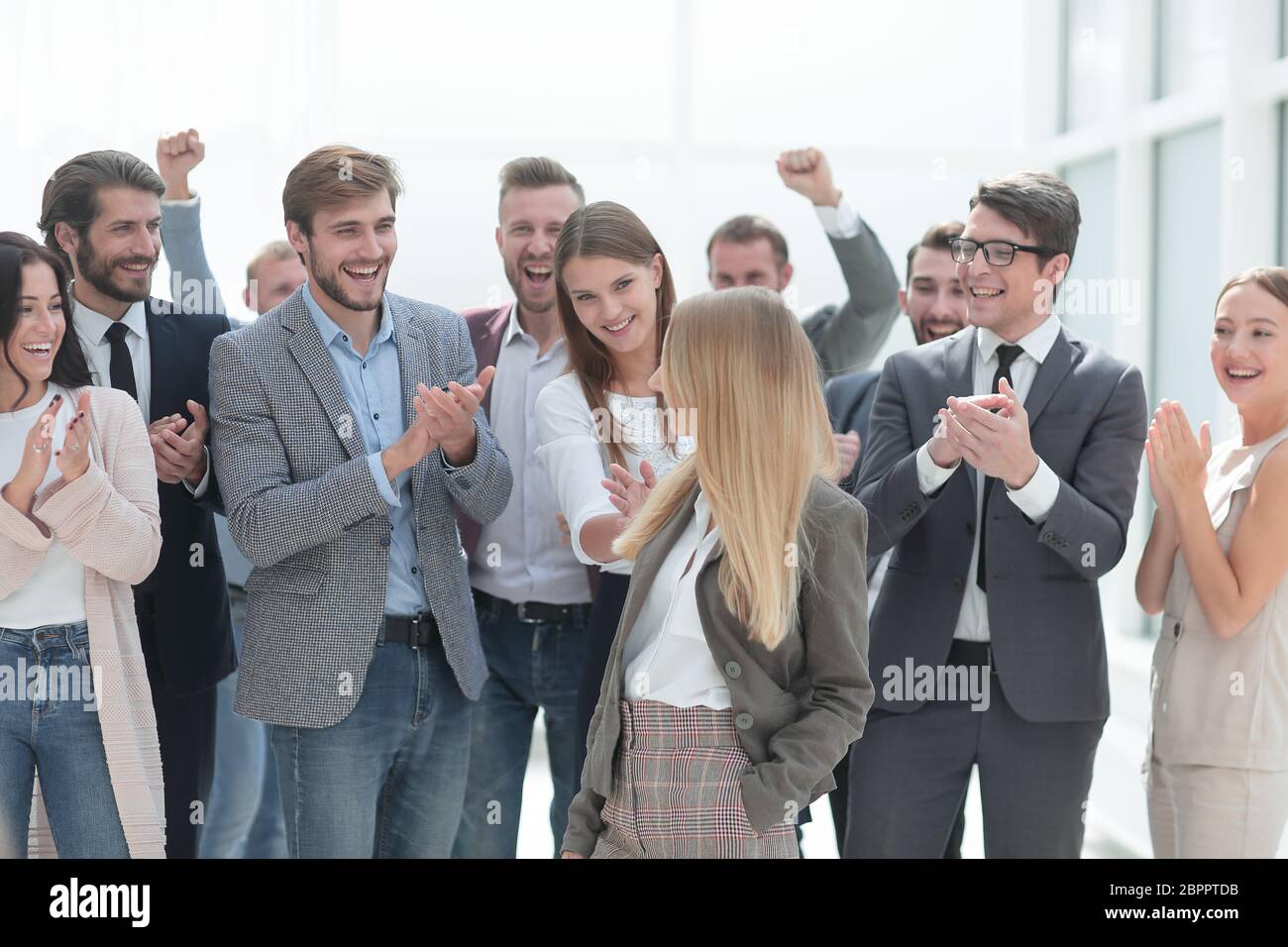 corporate group of employees applauding a young colleague Stock Photo ...