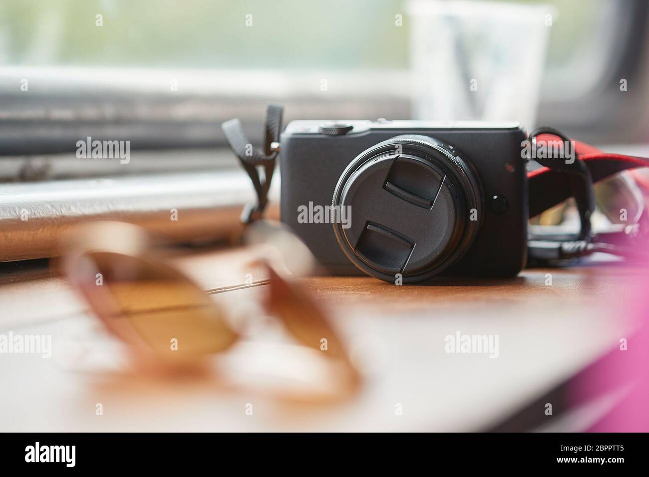 Small mirrorless travel camera on a table Stock Photo - Alamy