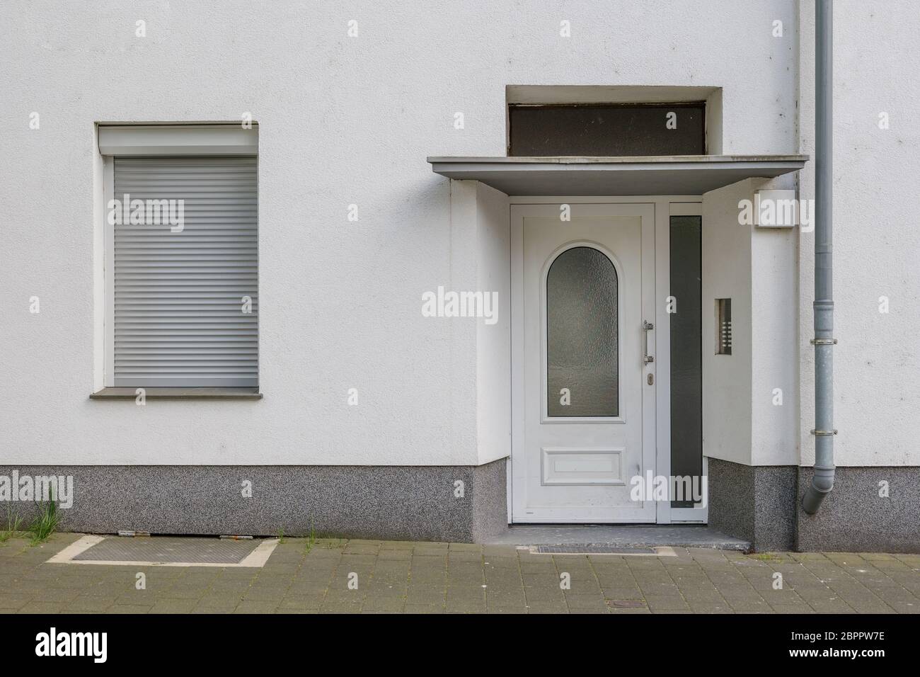Front view on sidewalk of typical facade with swing door, canopy and ...