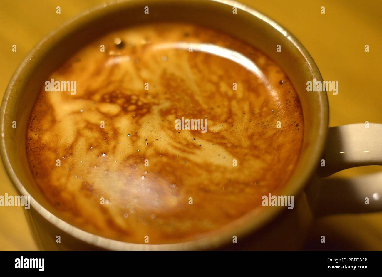 A cup of instant coffee with a little bit of milk, in close-up view ...