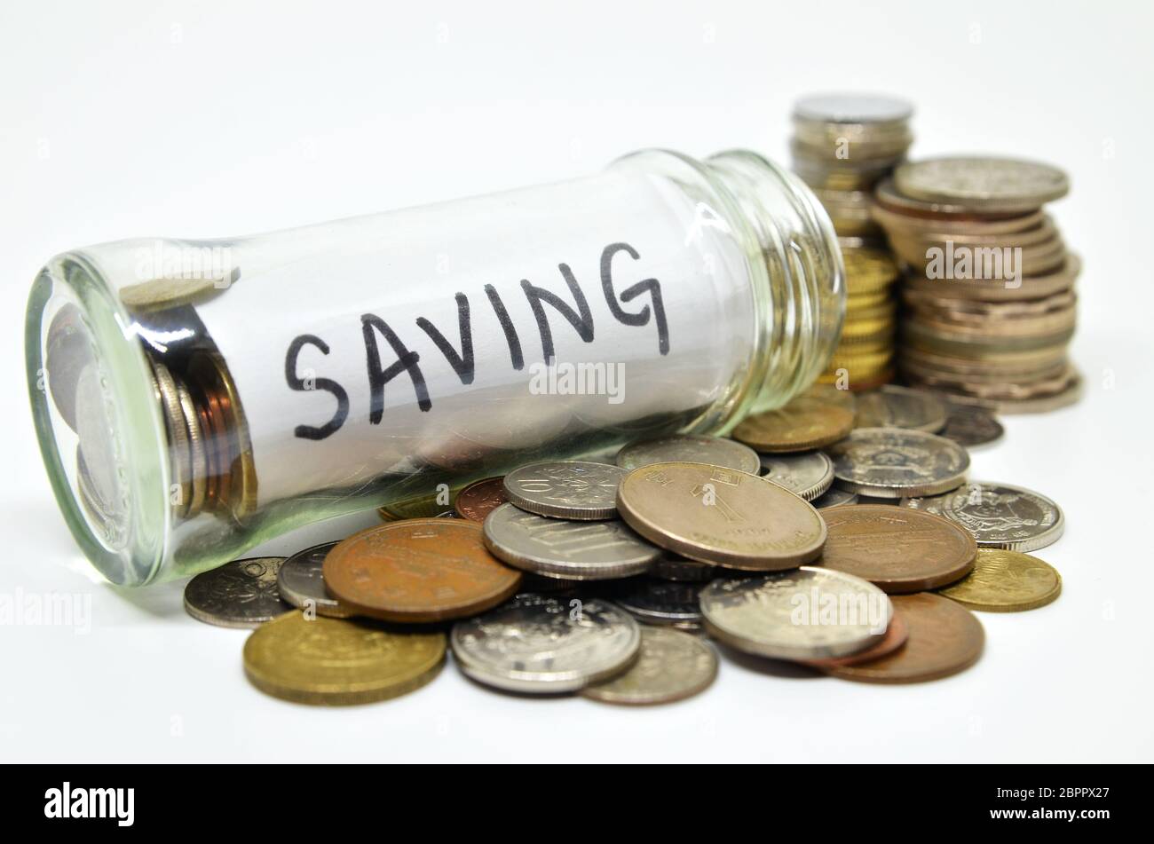 Saving lable in a glass jar with coins spilling out isolated on white ...