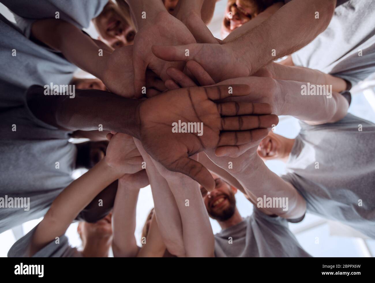 smiling young people making a tall tower out of their hands Stock Photo ...