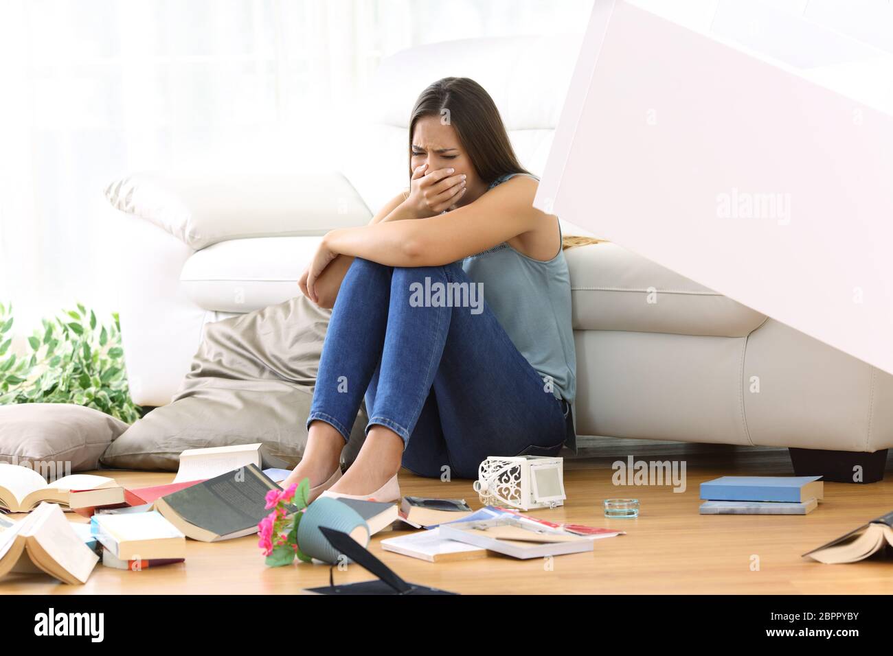 Sad homeowner lamenting after robbery sitting on the floor of the ...