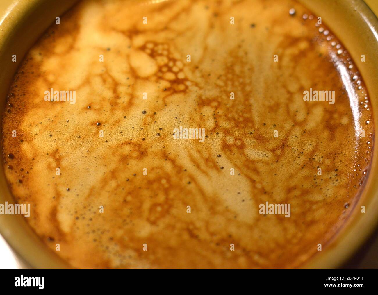 A cup of instant coffee with a little bit of milk, in close-up view ...