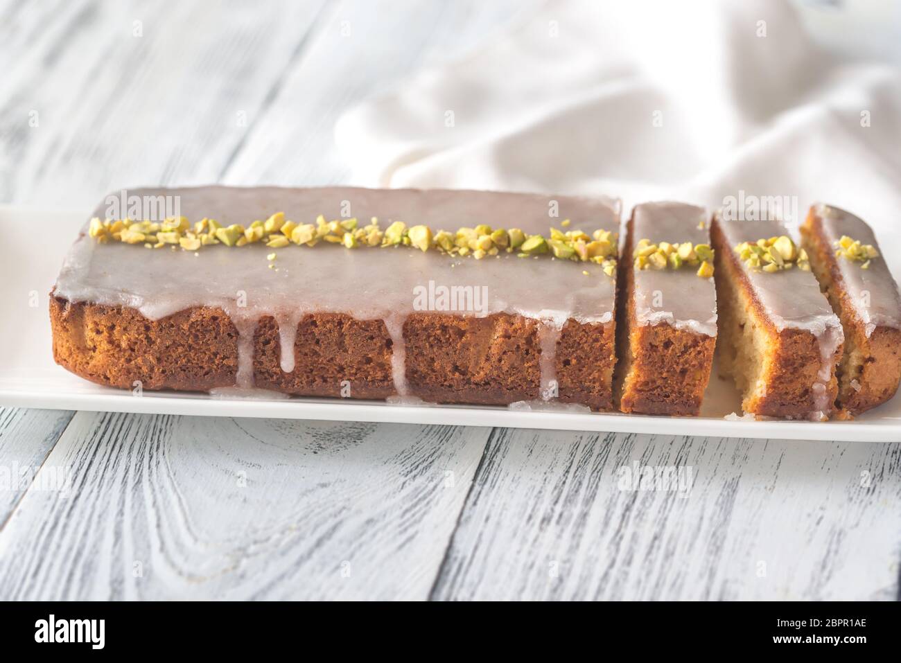 Lemon cake with icing decorated with pistachios: top view Stock Photo ...